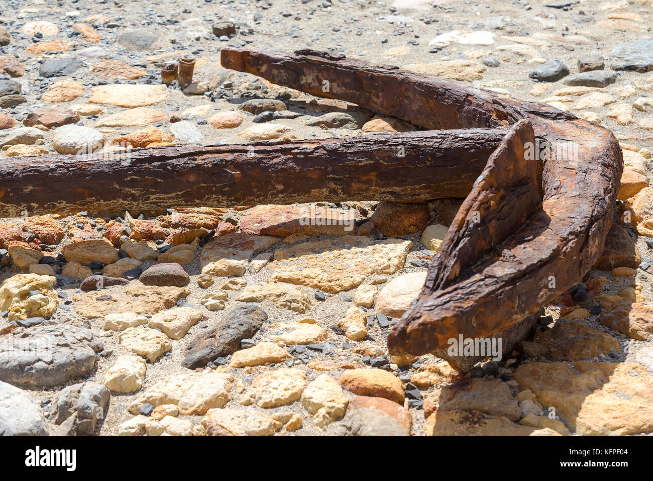 Old anchor is lying on the rocks near the port on the island of Crete ...