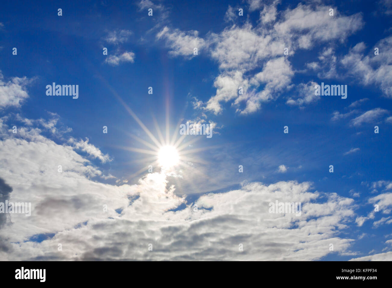 background from blue sky with white clouds and sun. spring landscape ...