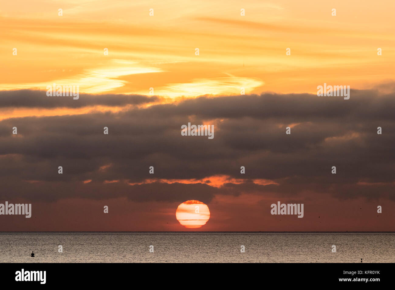 Sun risen above the horizon over the English Channel. Sun is a red ball ...