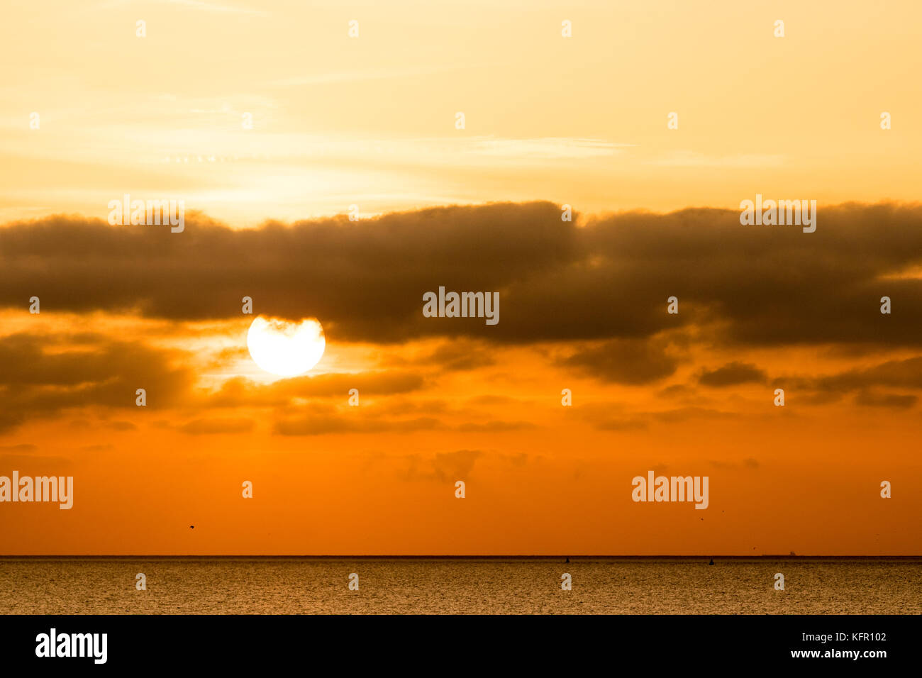 Sun rising over the English Channel. Sun above the horizon partly ...