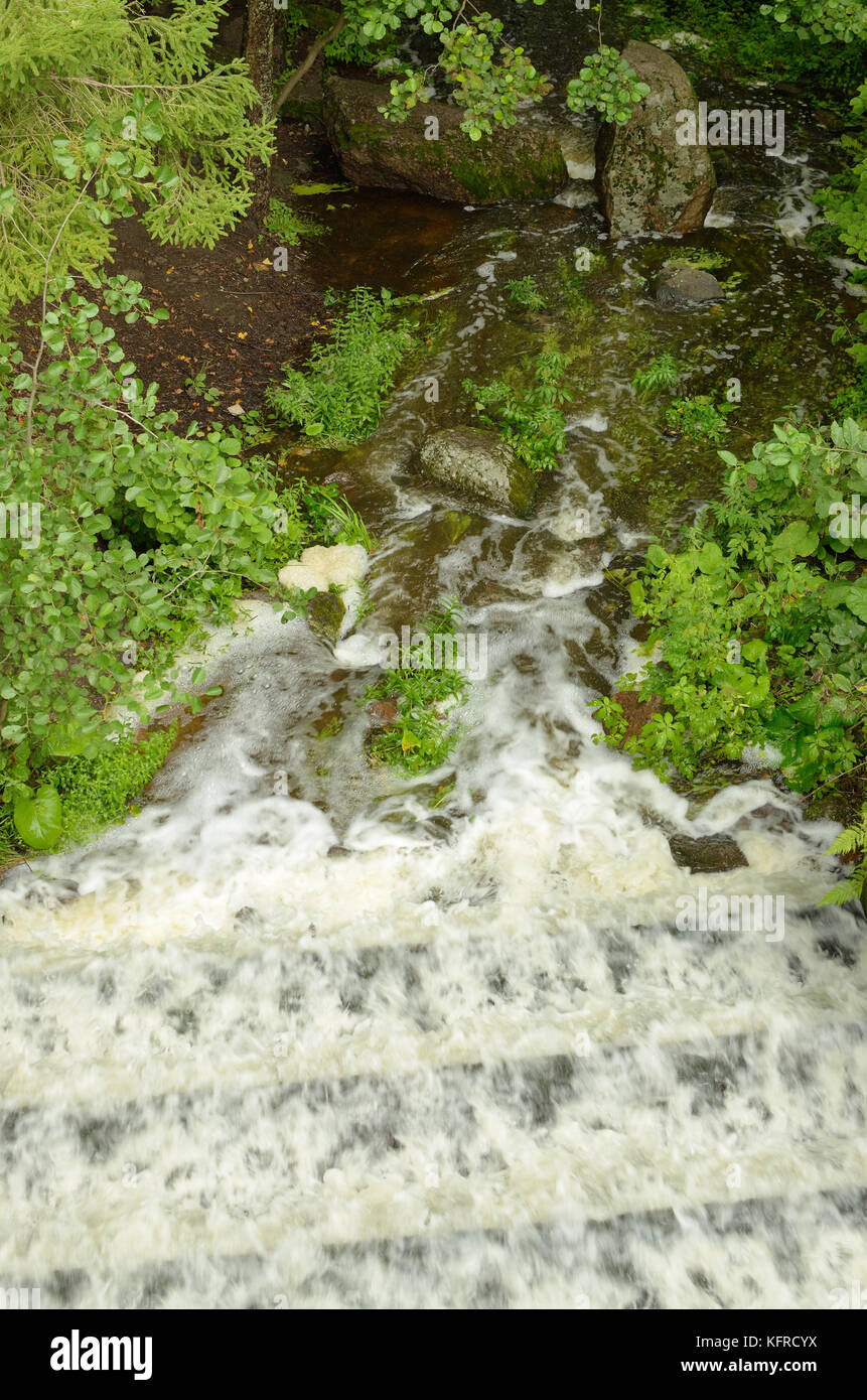 The river is rapidly flowing from under the bridge down,forming a ...
