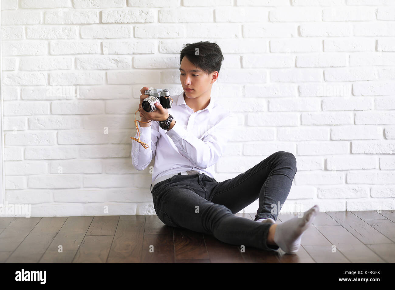 Asian young man with a camera Stock Photo - Alamy