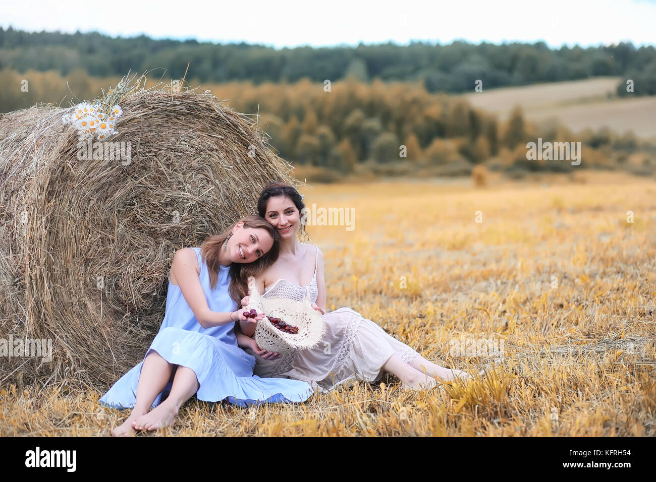 Two girls in dresses in autumn field Stock Photo - Alamy