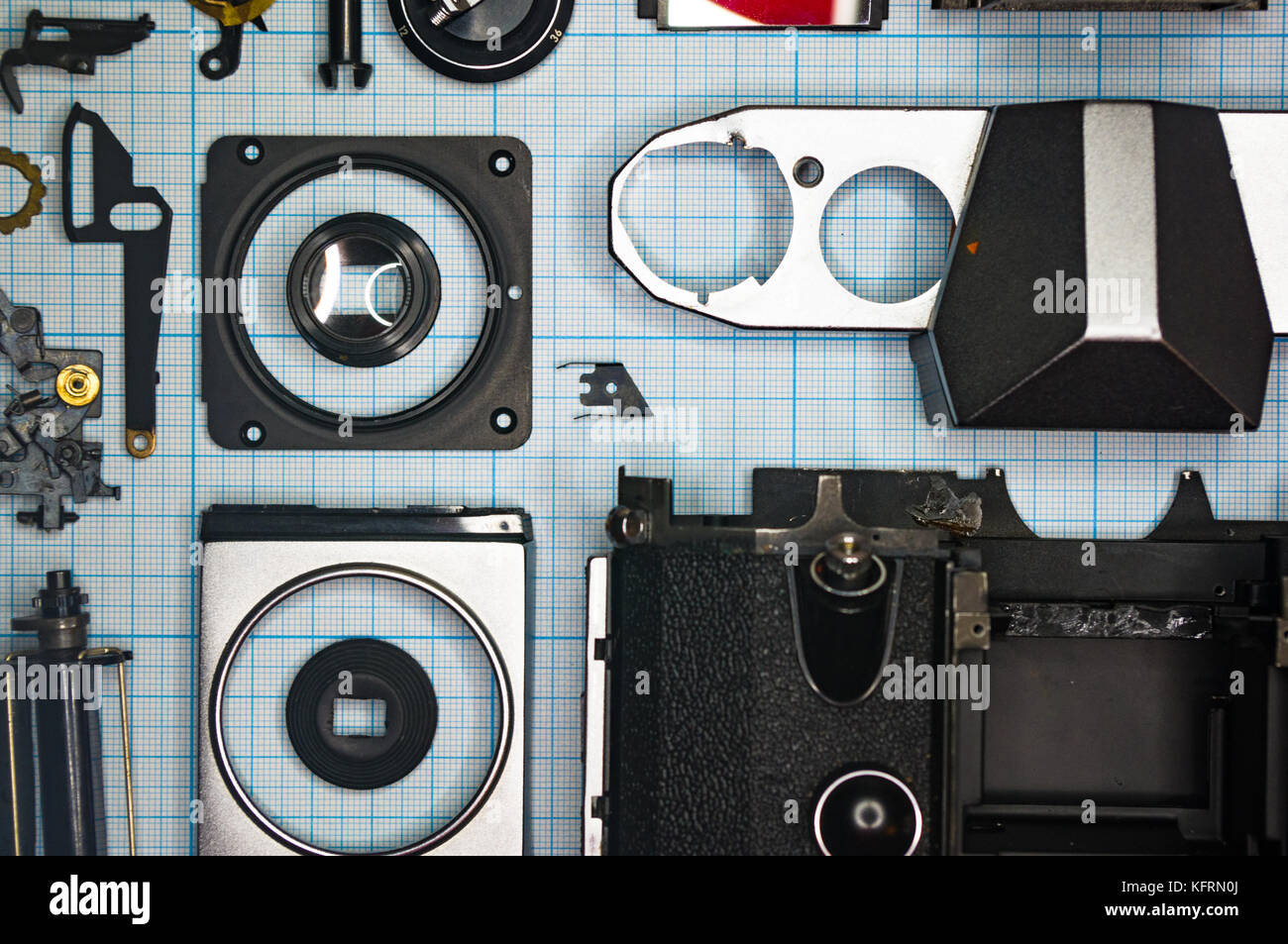 parts are completely disassembled old retro film SLR camera on graph ...
