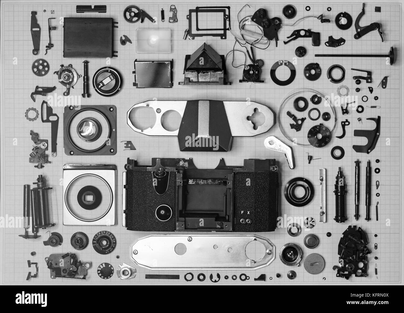parts are completely disassembled old retro film SLR camera on graph ...