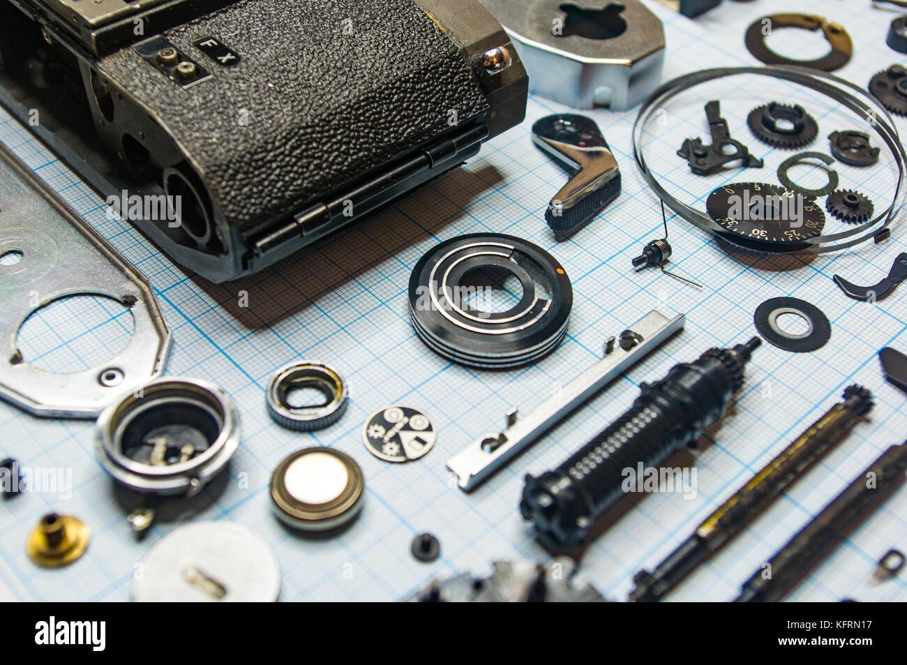 parts are completely disassembled old retro film SLR camera on graph ...
