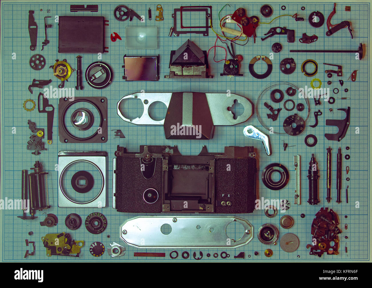 parts are completely disassembled old retro film SLR camera on graph ...