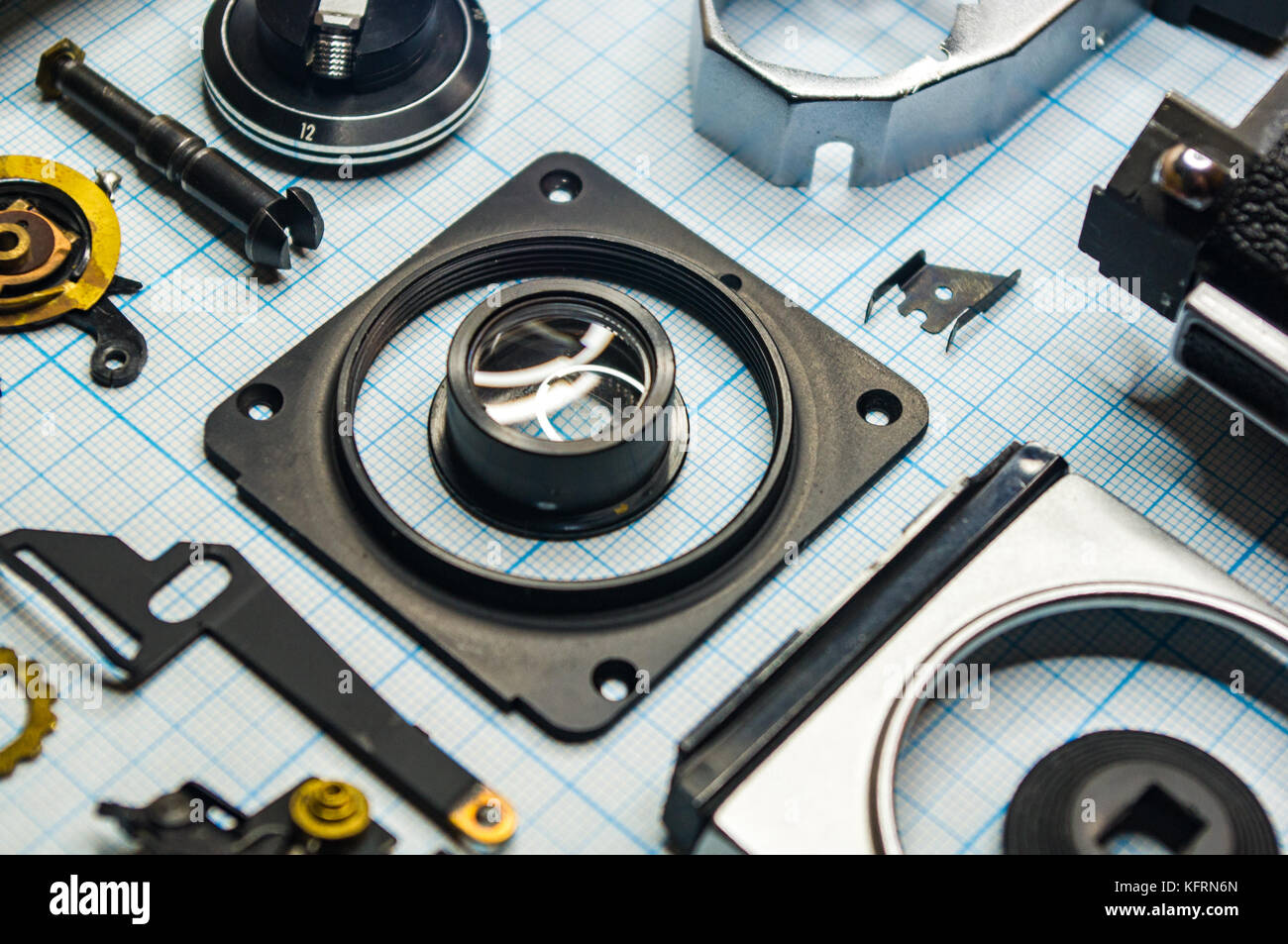 parts are completely disassembled old retro film SLR camera on graph ...