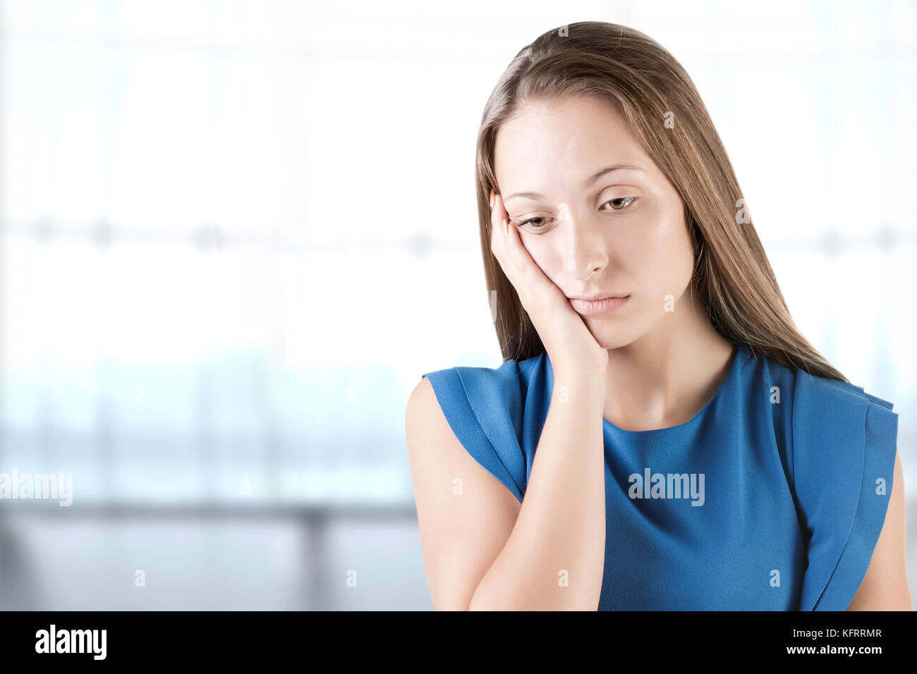 Sad and bored woman thinking about something, in a blue background ...