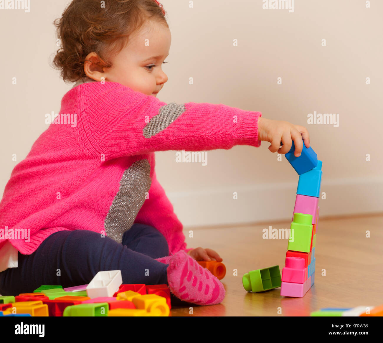 Toddler baby girl plays with soft rubber building blocks Stock Photo ...