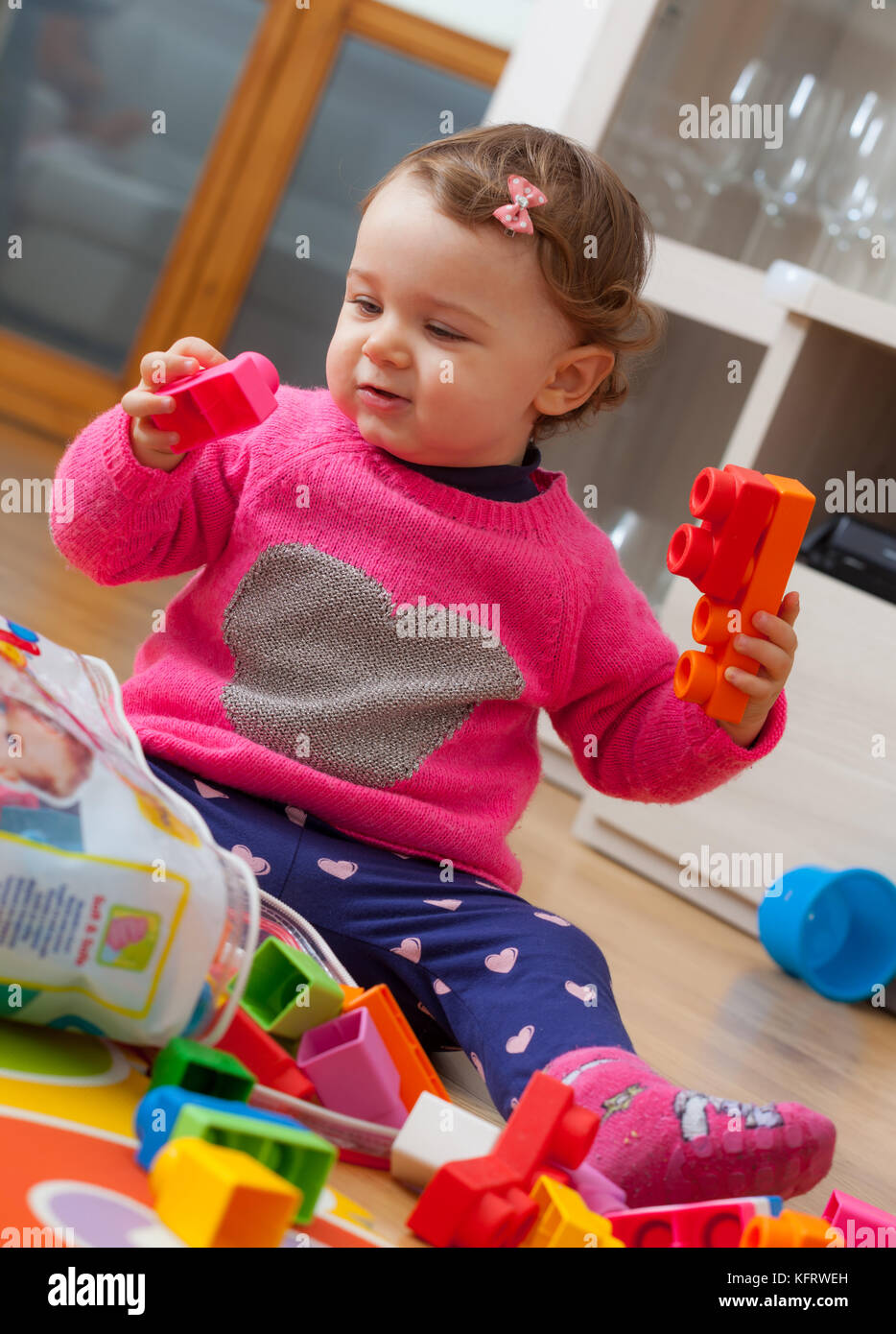 Toddler baby girl plays with soft rubber building blocks Stock Photo ...