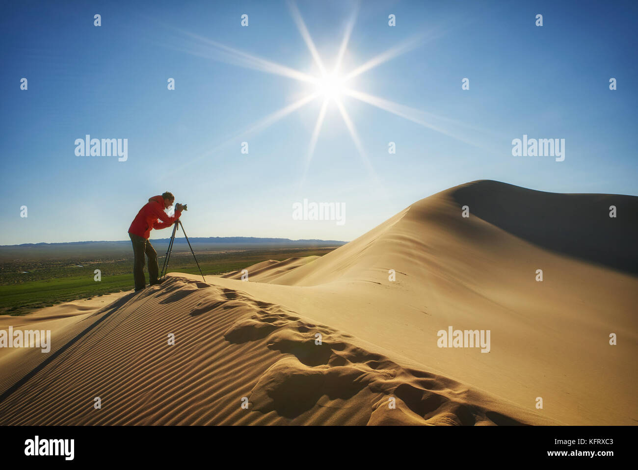Man taking pictures in the sunny desert Stock Photo - Alamy