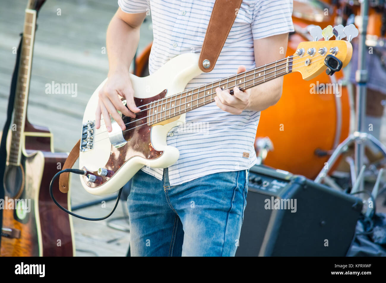 Close up of man playing bass guitar outdoors Stock Photo - Alamy