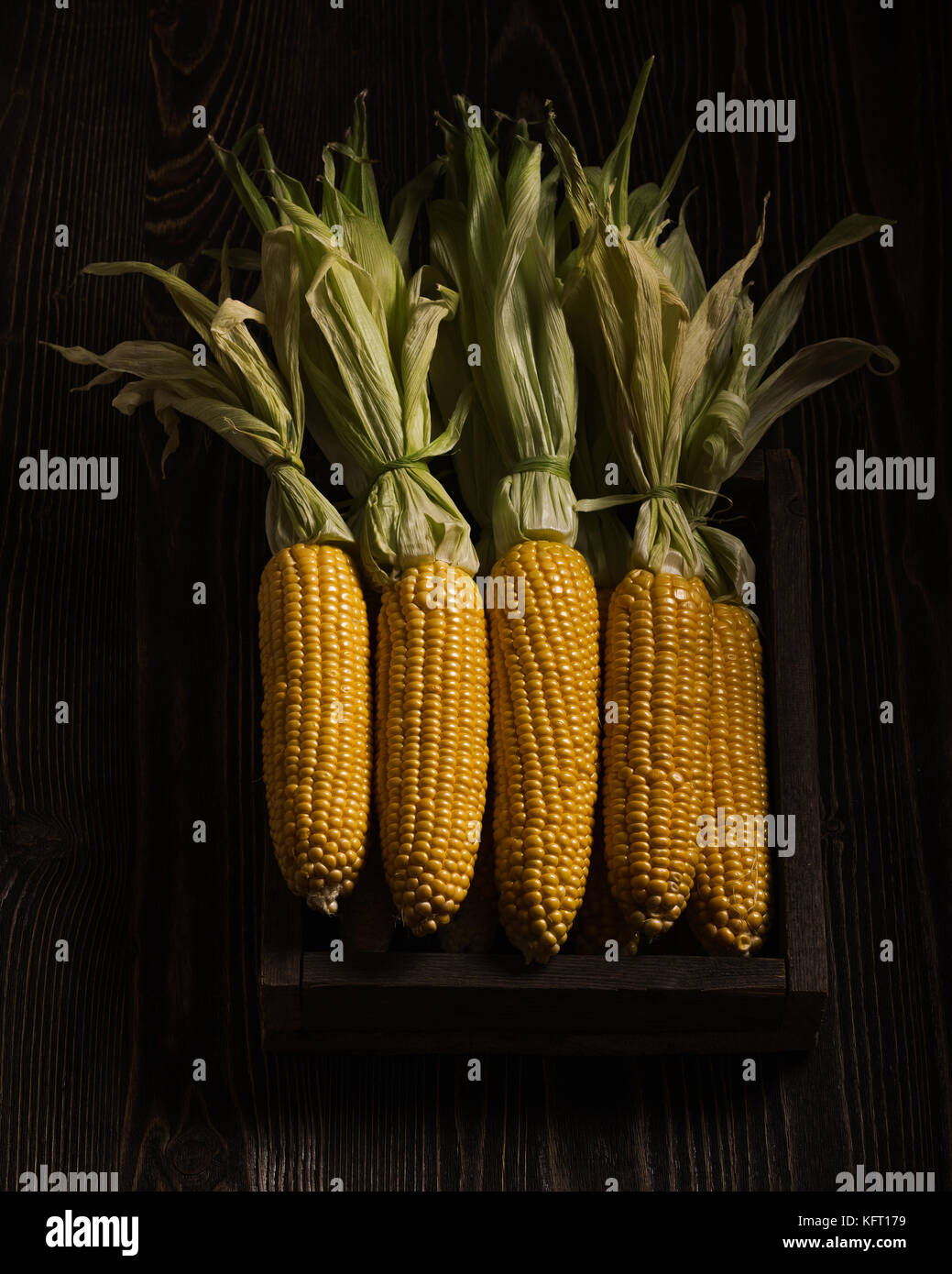 Box full of fresh corn cobs on the dark rough wood Stock Photo - Alamy