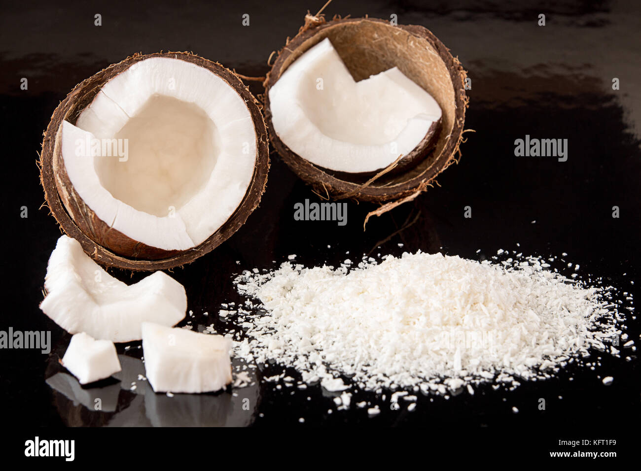 Half of coconut, pieces of coconut, coconut flakes on black background ...