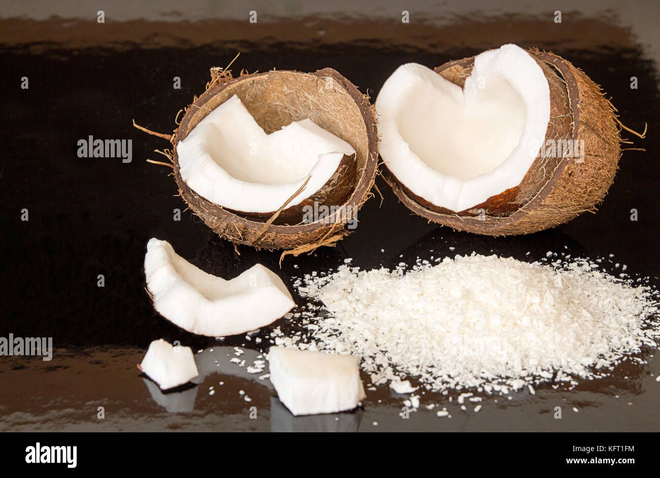 Halfs of coconut, pieces of coconat, coconut flakes on black background ...