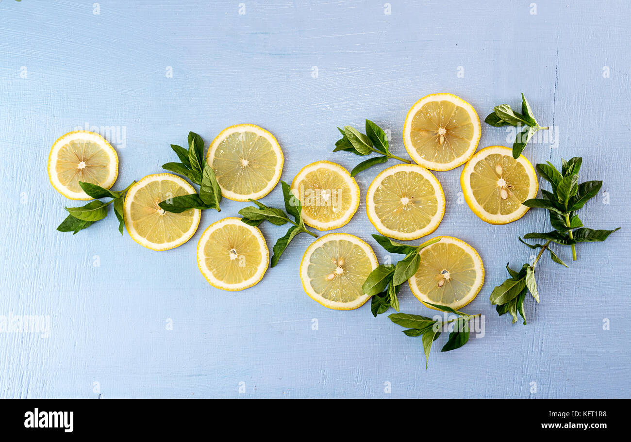 Flat lay still life with mint and lemon on blue background. Pop art ...