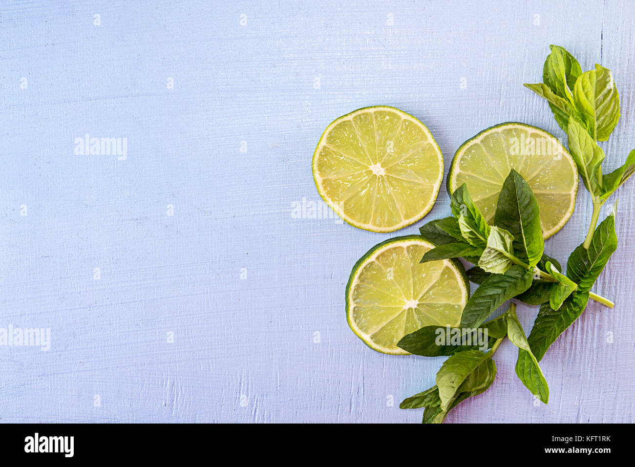 Flat lay still life with mint and lime on blue background. Pop art ...