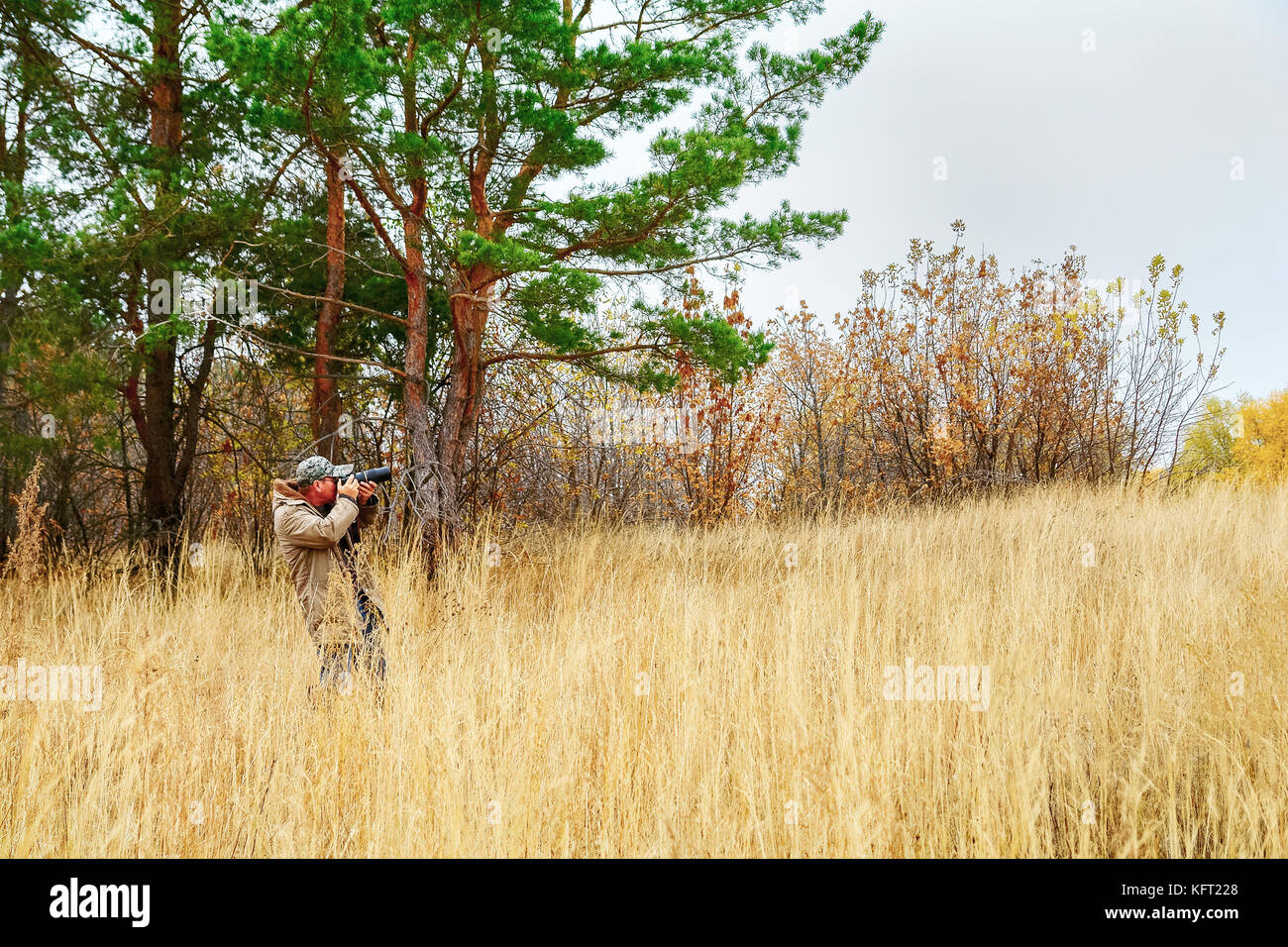 Photographer in a raincoat pictures of nature Stock Photo - Alamy