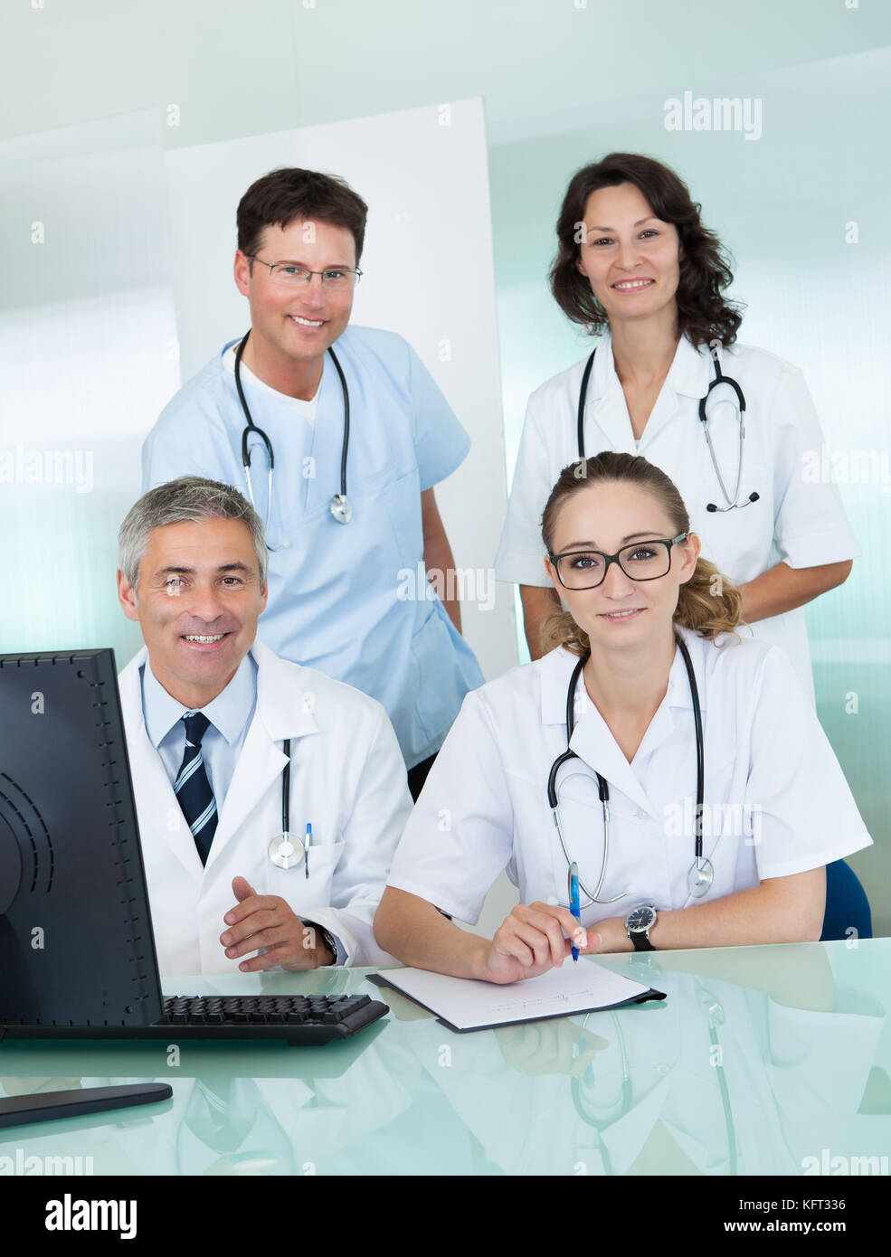 Medical team comprising male and female doctors posing together in an ...