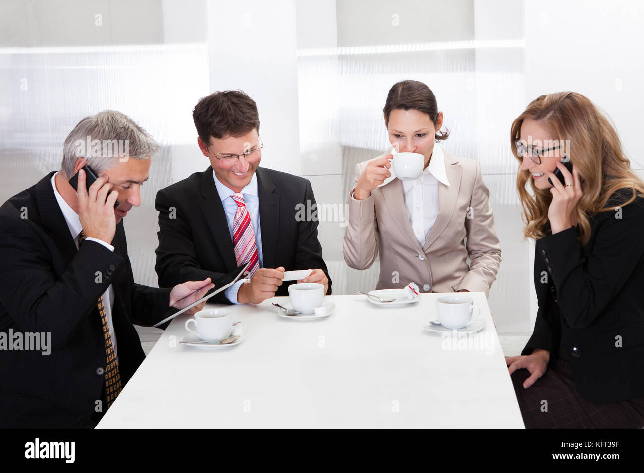 Executives Sitting Around Meeting Table High Resolution Stock ...
