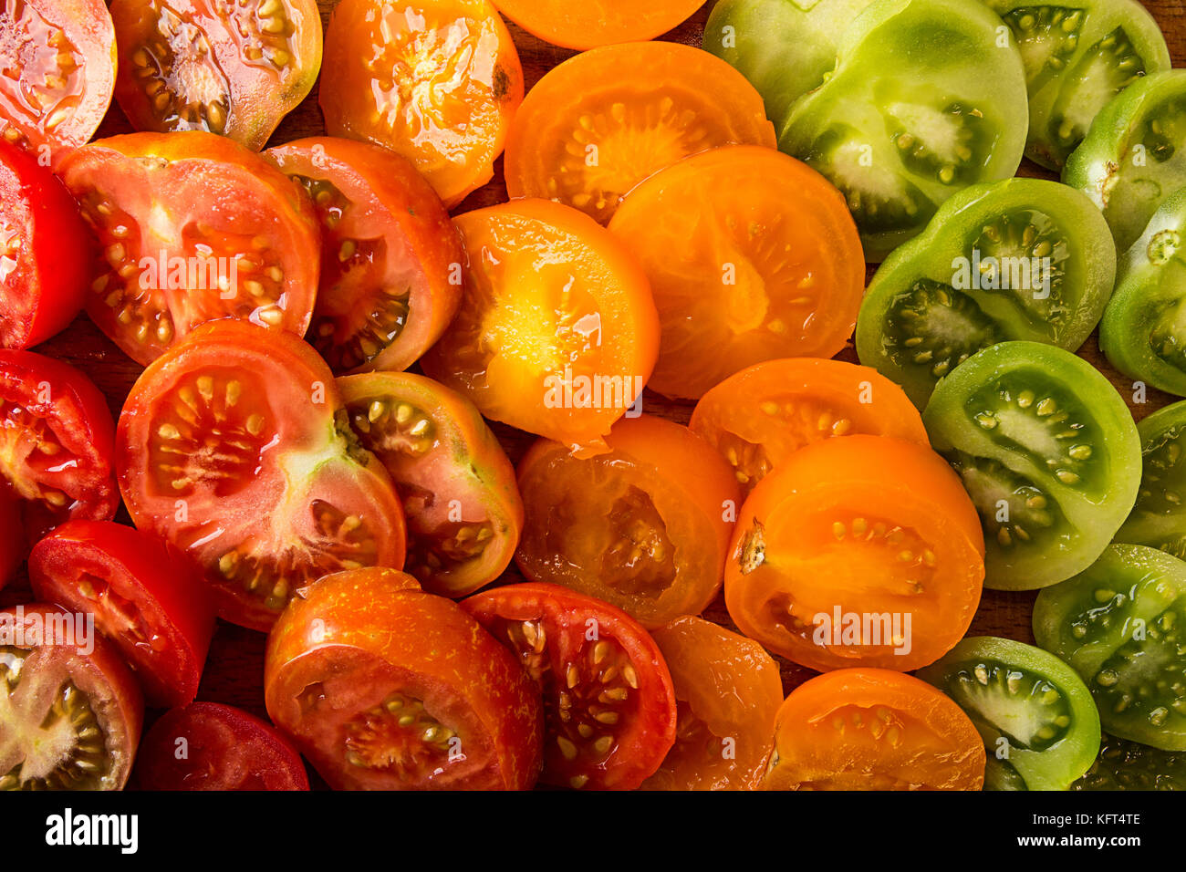 Various different color organic homegrown tomatoes on board. Cut red ...