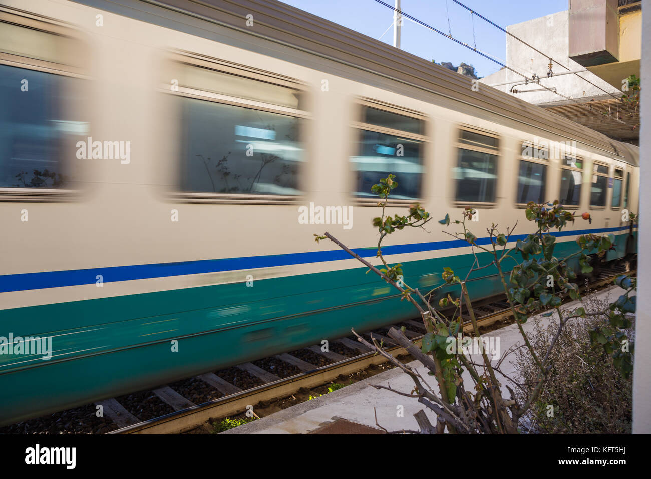 Passing at speed train at a railway station Stock Photo - Alamy