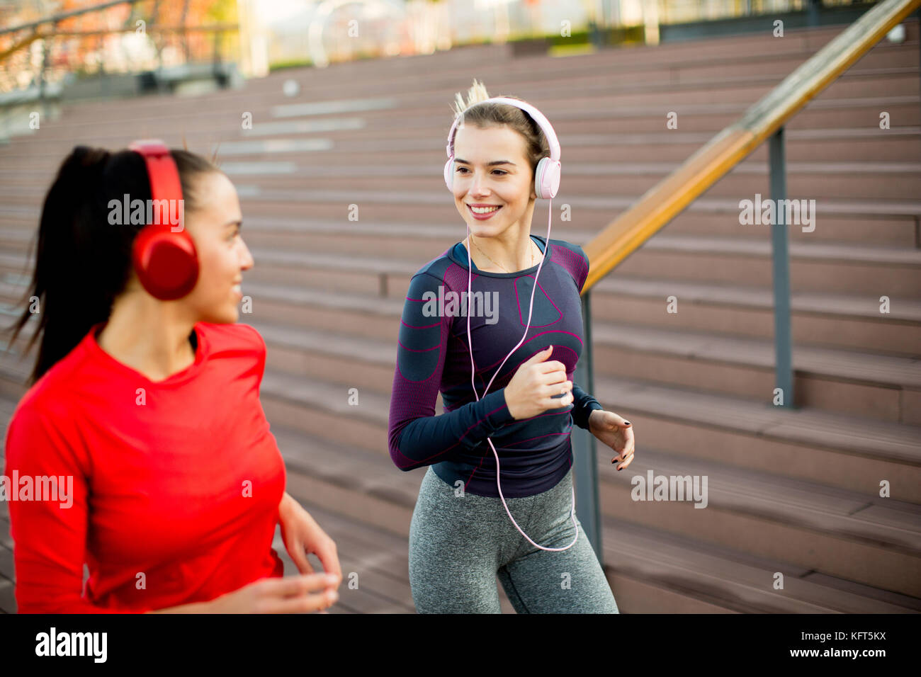 Two young women running in urban area Stock Photo - Alamy