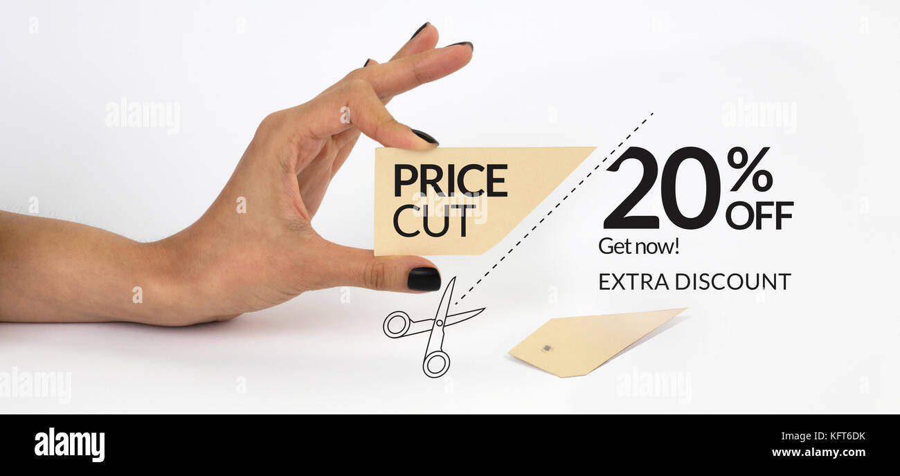 Female hand with black nails, holding scissors and cutting a price tag ...