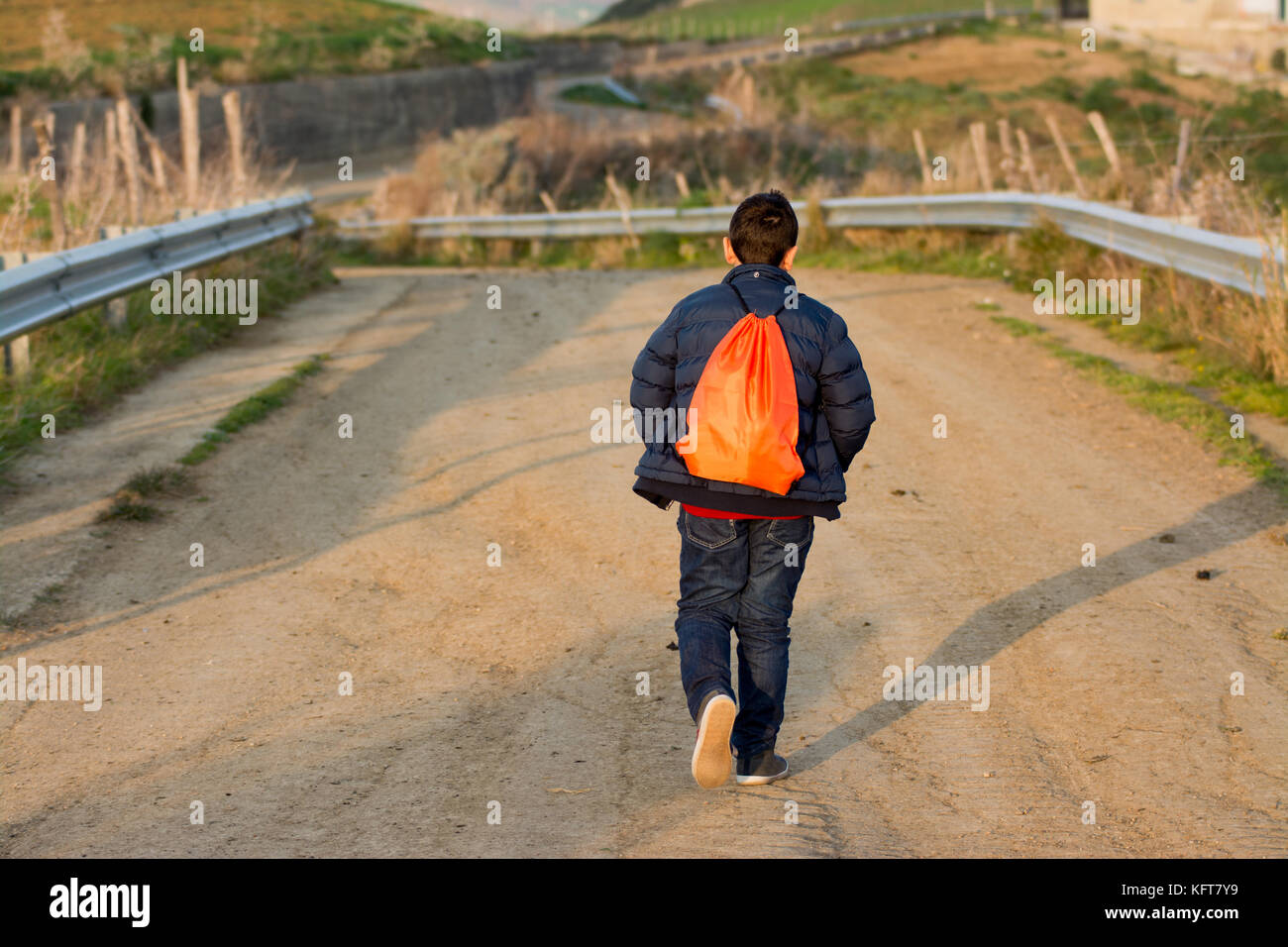 Teenager walking away on rough road. Concept of escape and adventure ...