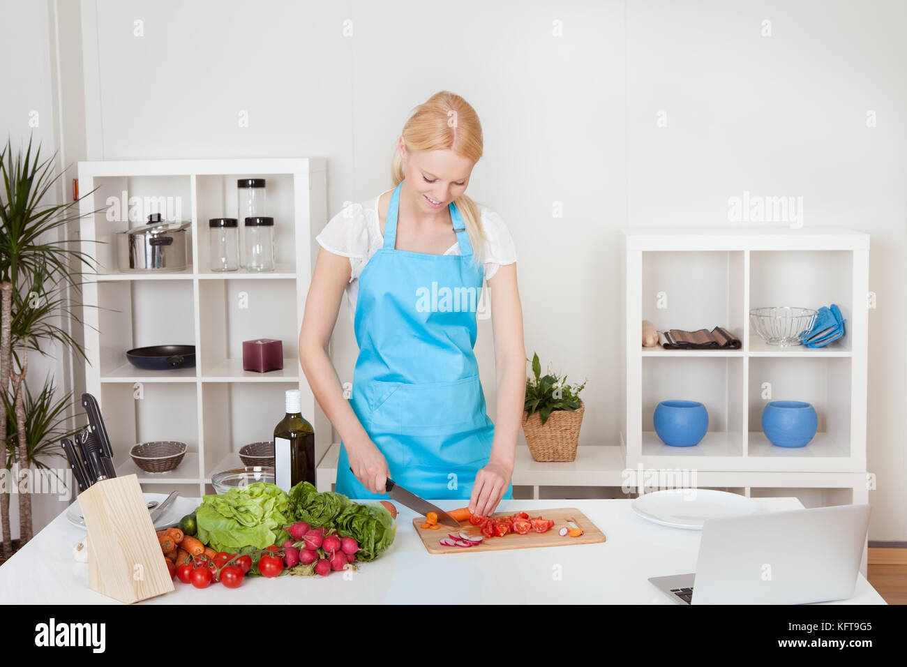 Cheerful young woman cooking in the kitchen Stock Photo - Alamy