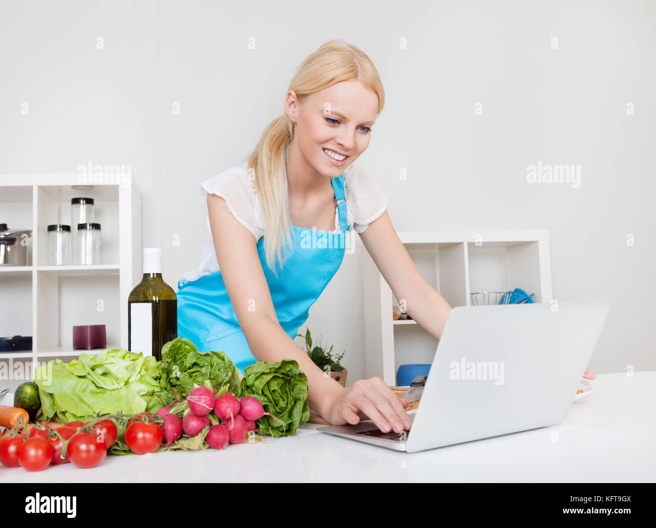 Cheerful young woman cooking in the kitchen Stock Photo - Alamy