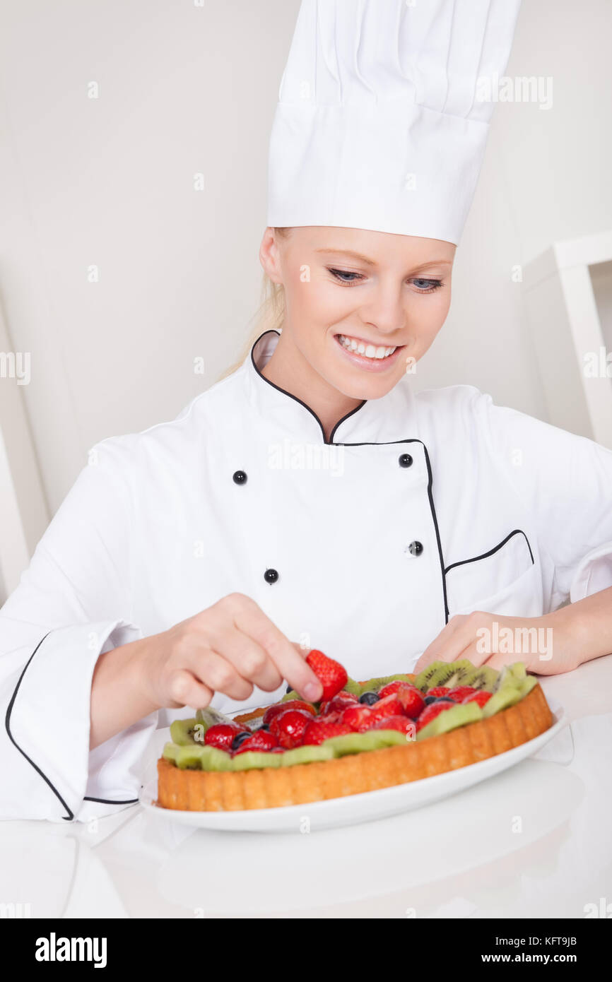 Beautiful chef woman making cake in the kitchen Stock Photo - Alamy