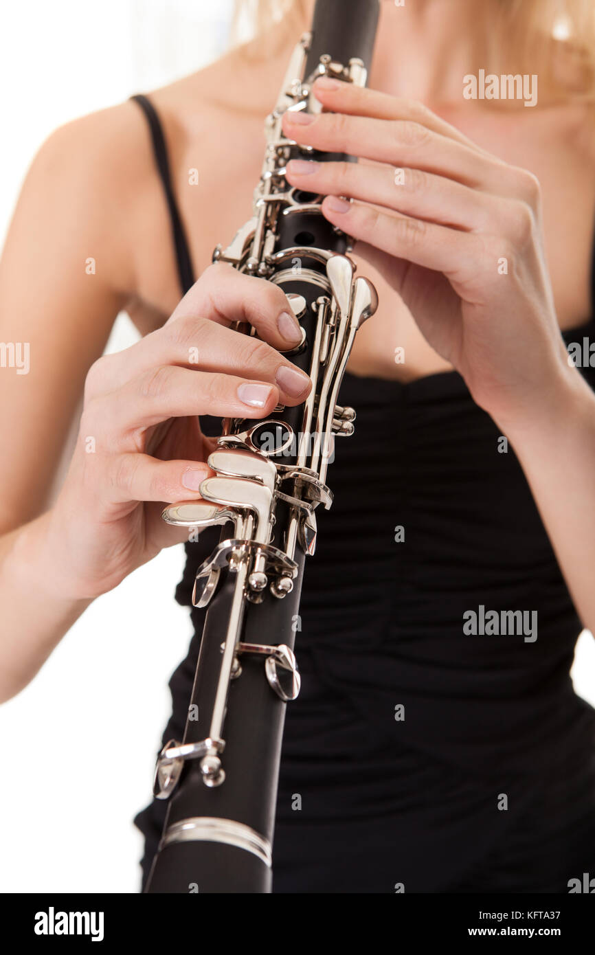 Beautiful young woman playing clarinet over black background Stock ...