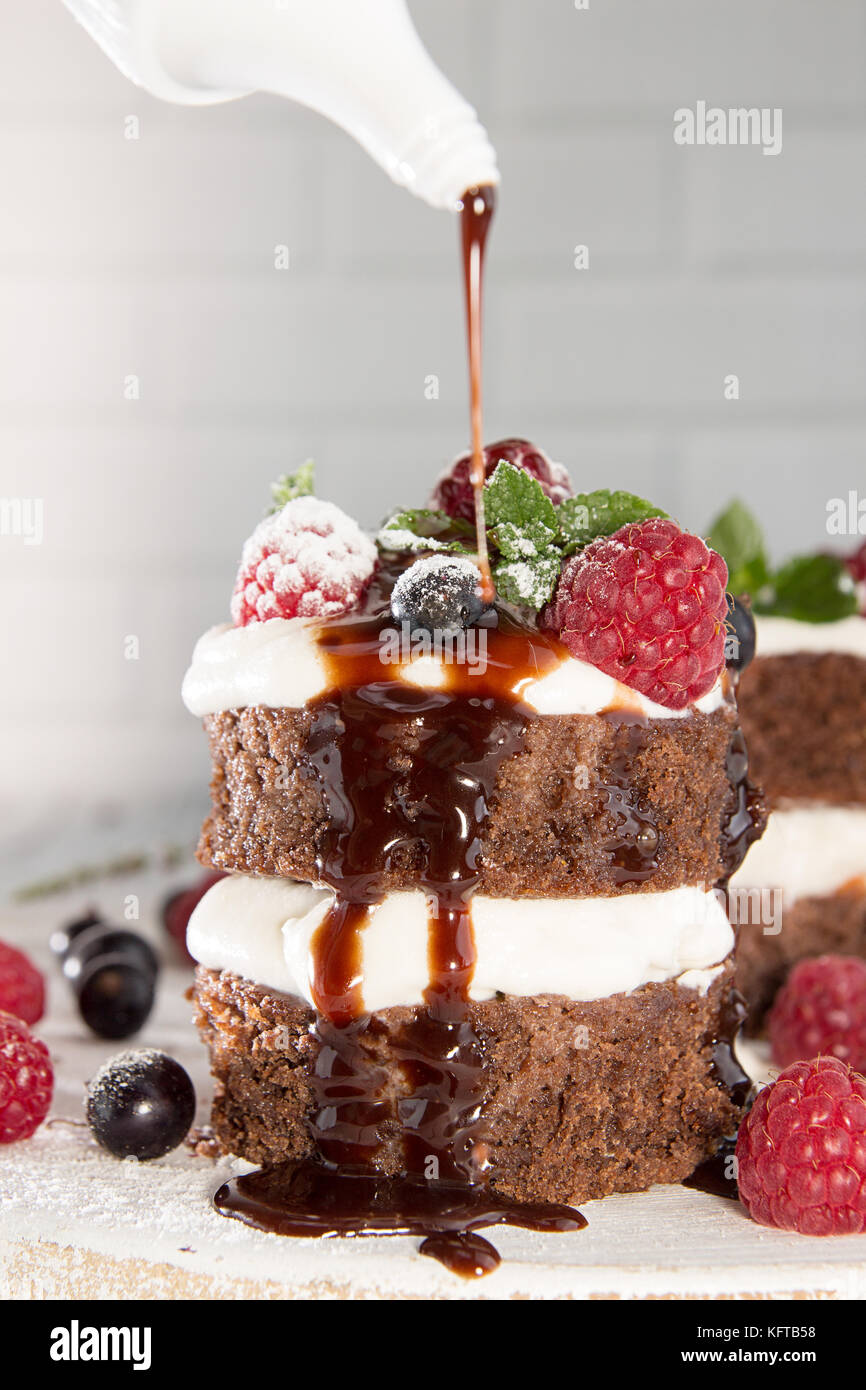 Chocolate cake decorated with raspberry, wipped cream, chocolate sauce ...