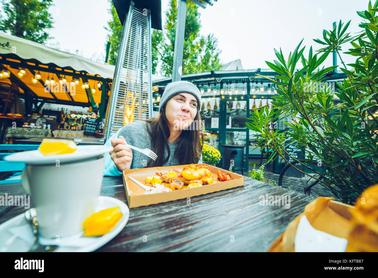 Beautiful woman eating in outside cafe Stock Photo - Alamy
