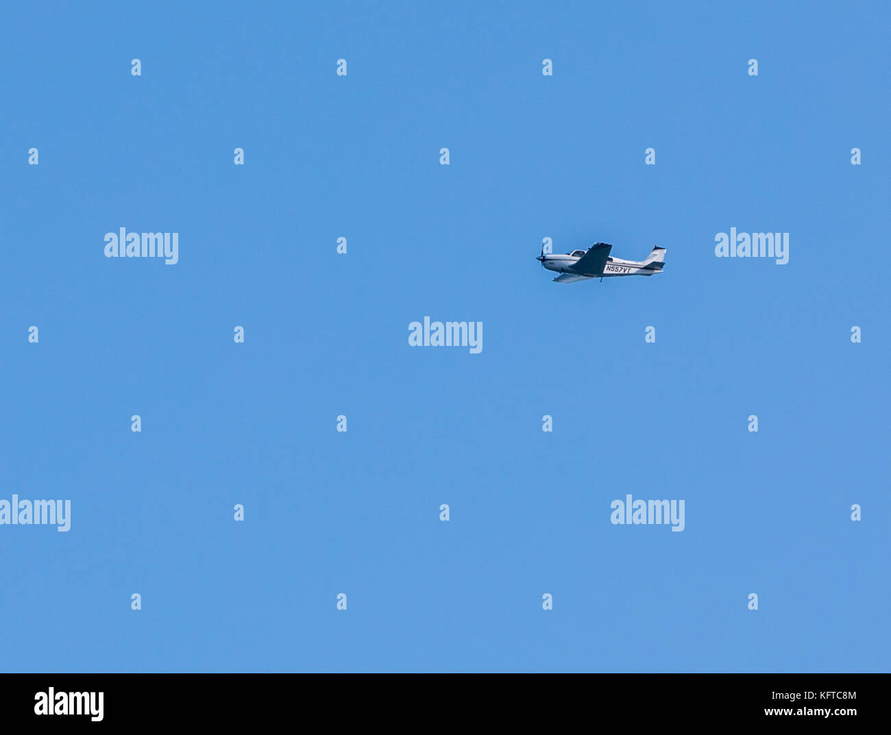 small single engine plane in a brillant blue sky in the hamptons, long ...