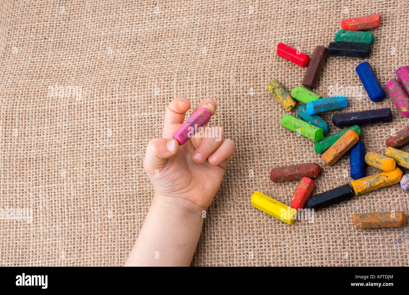 Used color crayons and a toddlers hand holding one Stock Photo - Alamy