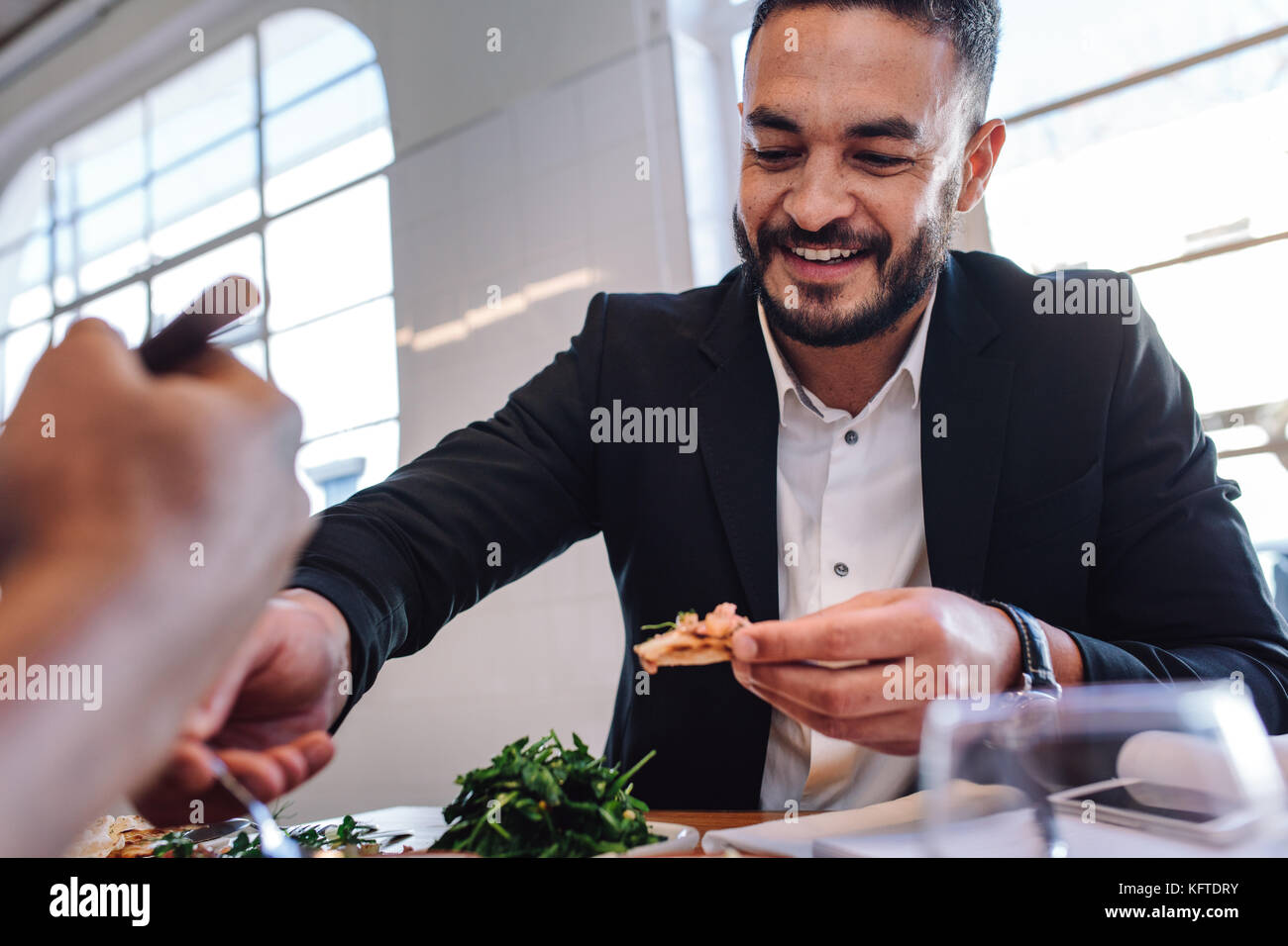 Young businessman having food in restaurant. Happy caucasian man ...