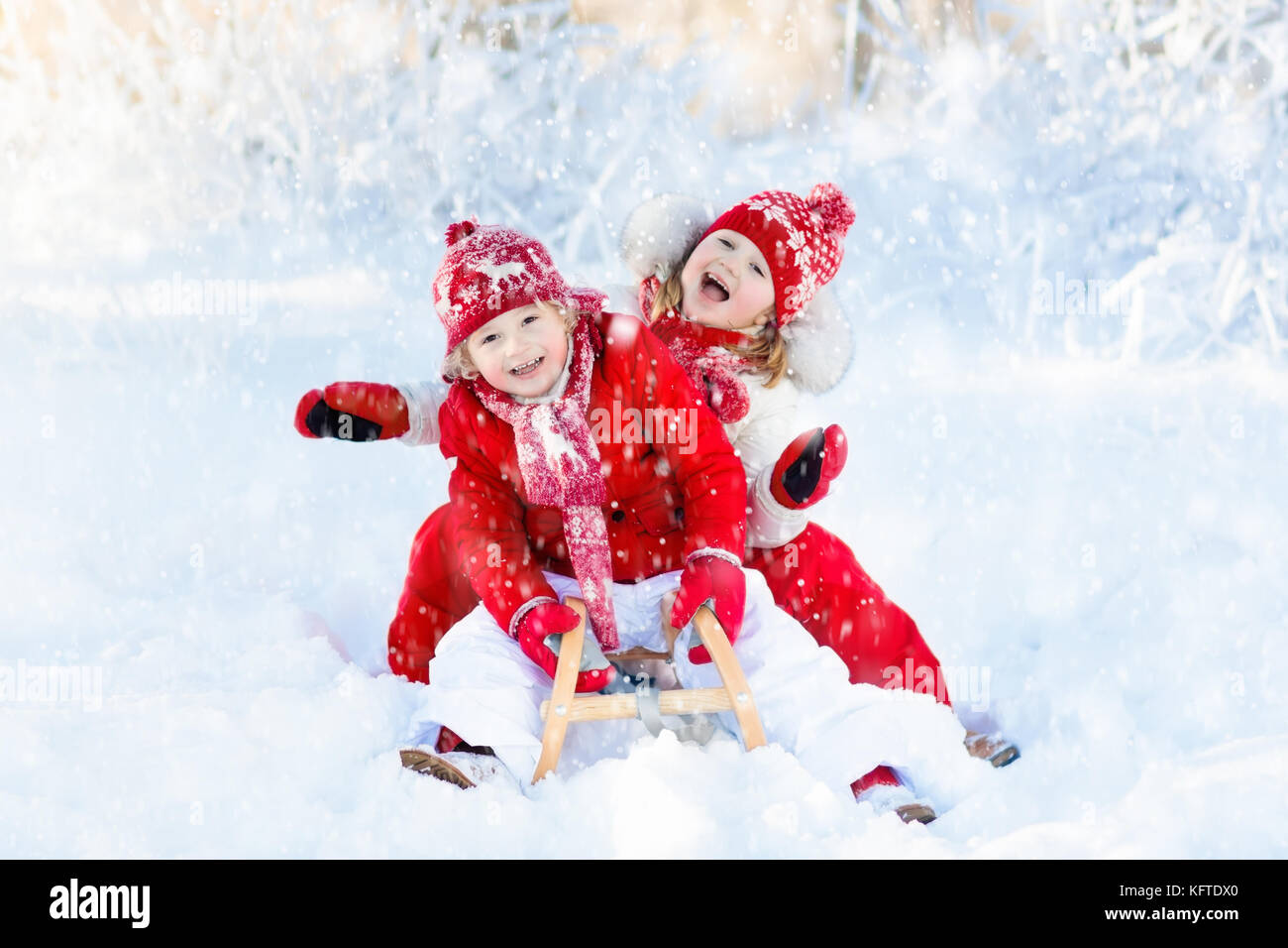 Little girl and boy enjoying sleigh ride. Child sledding. Toddler kid ...