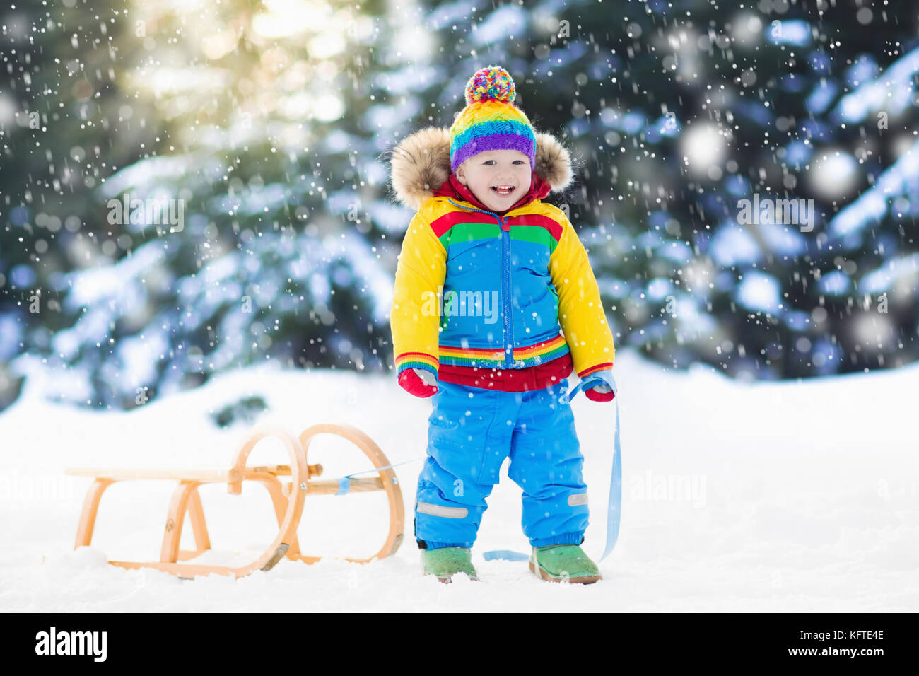 Little boy enjoying a sleigh ride. Child sledding. Toddler kid riding a ...