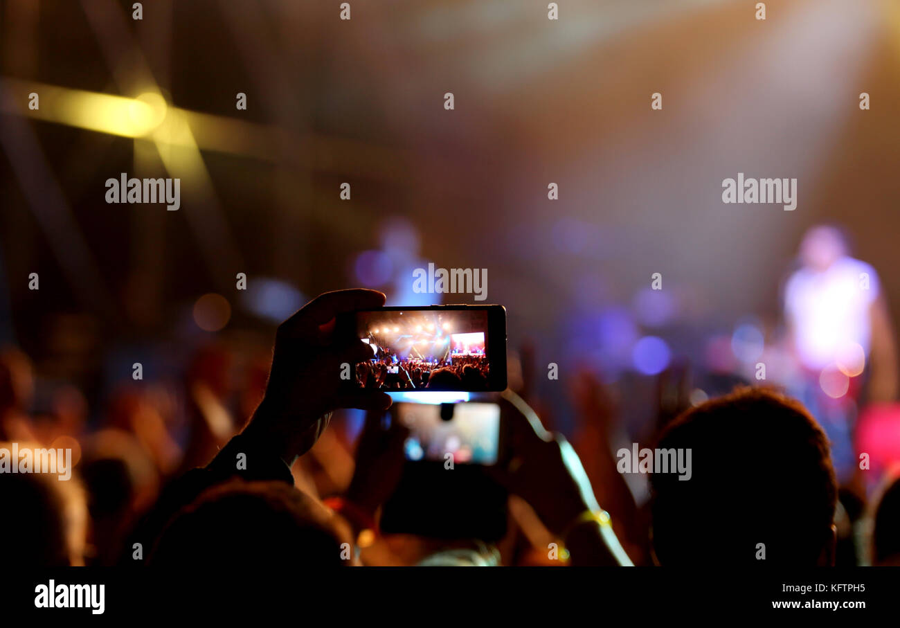 fans who take photos and record videos with modern smartphones during ...