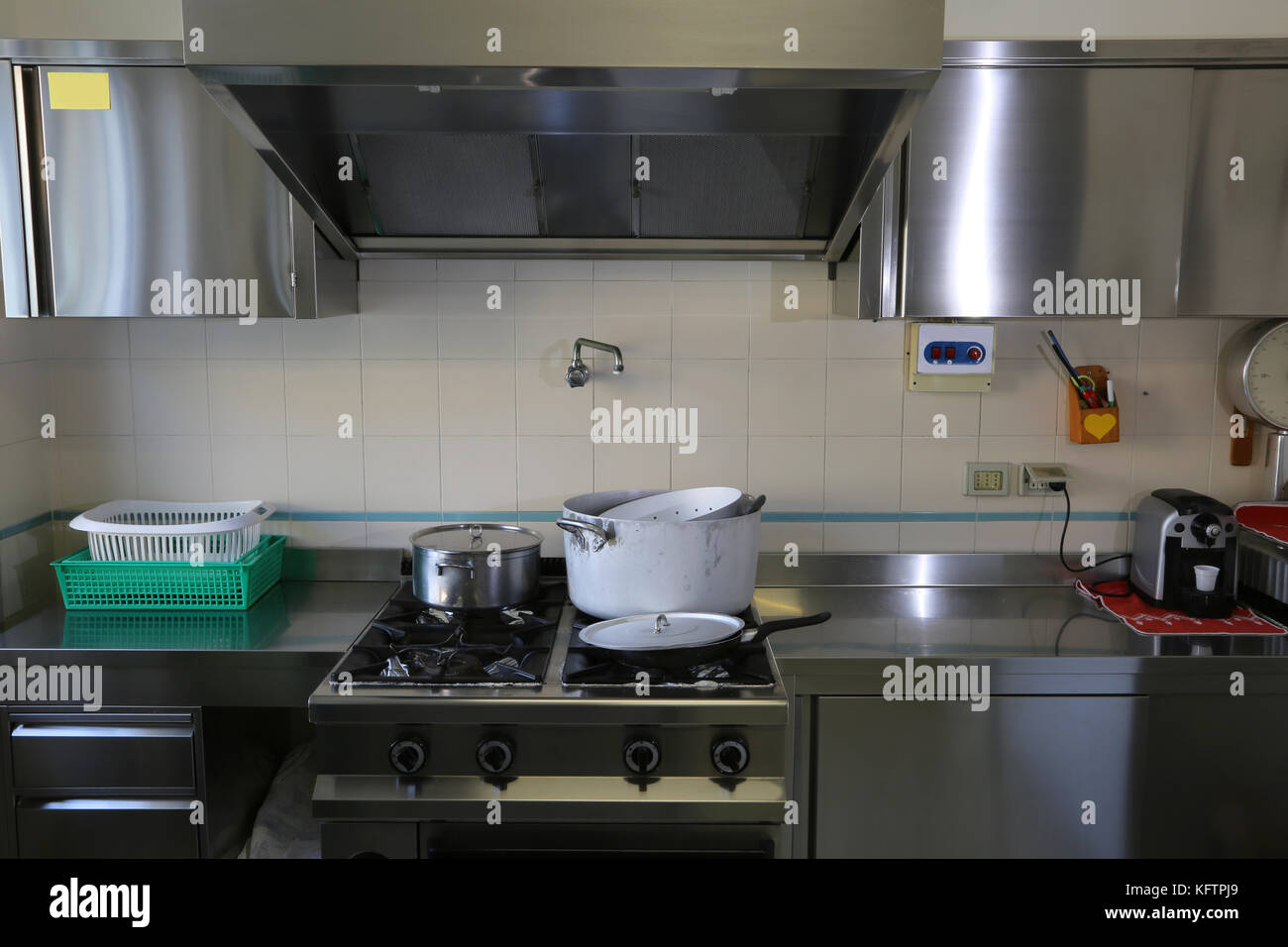 large industrial kitchen with stainless steel cookers and large suction ...