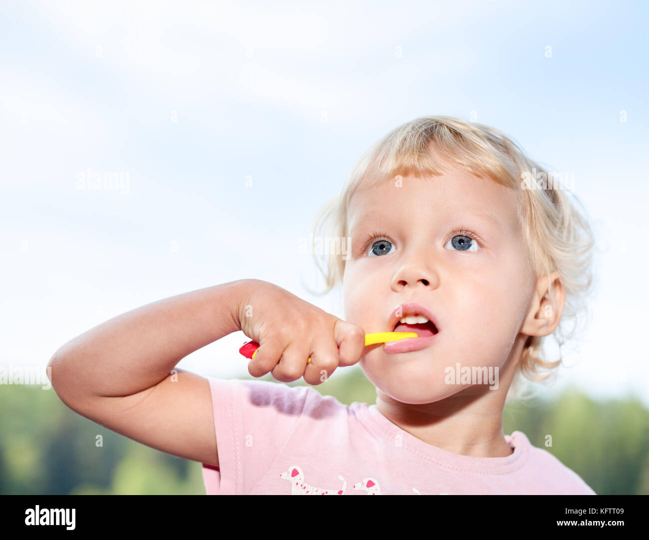 Portrait of cute little girl brushing teeth outdoor Stock Photo - Alamy