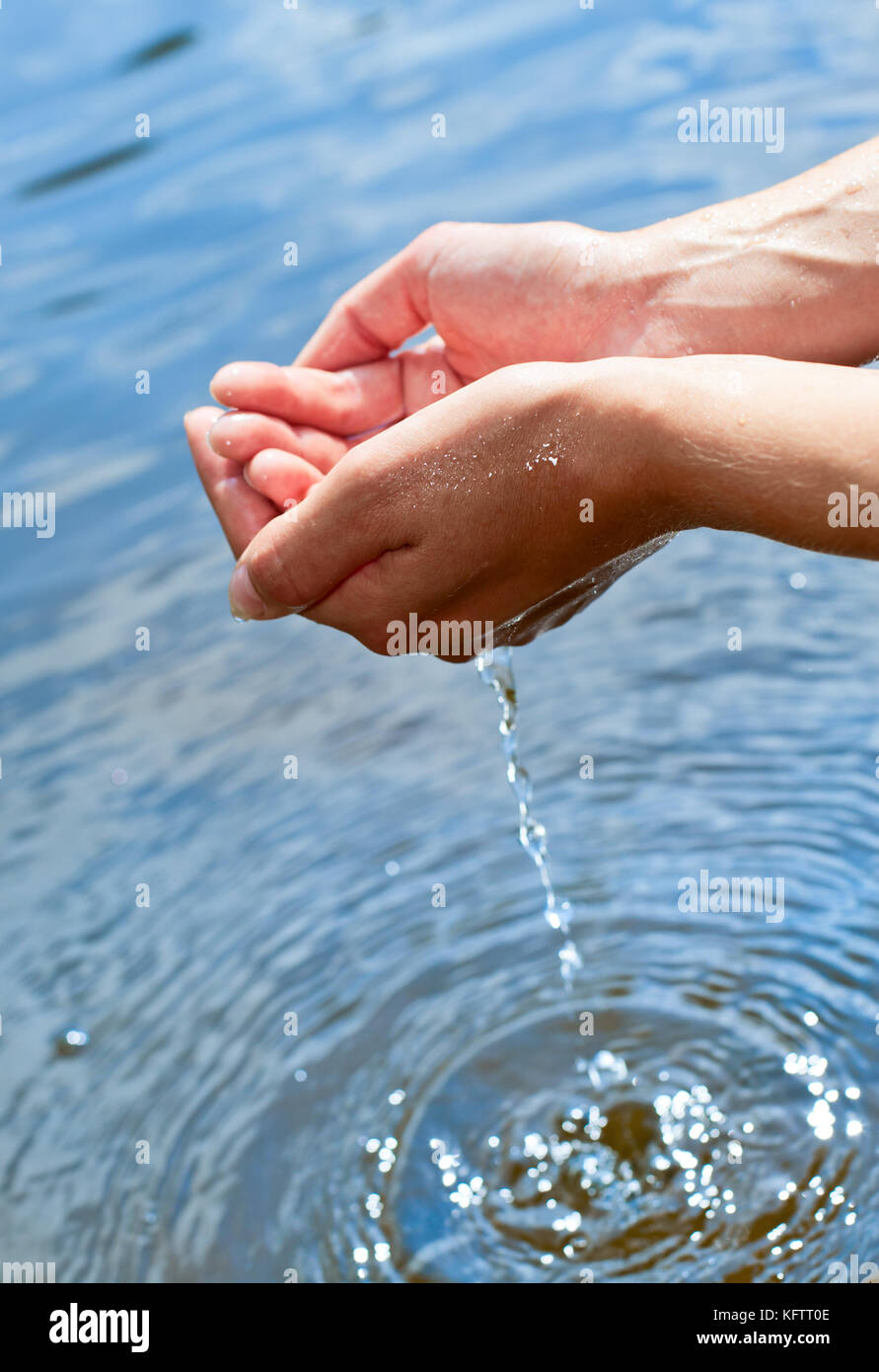 Water pouring out of a young woman's hands Stock Photo - Alamy