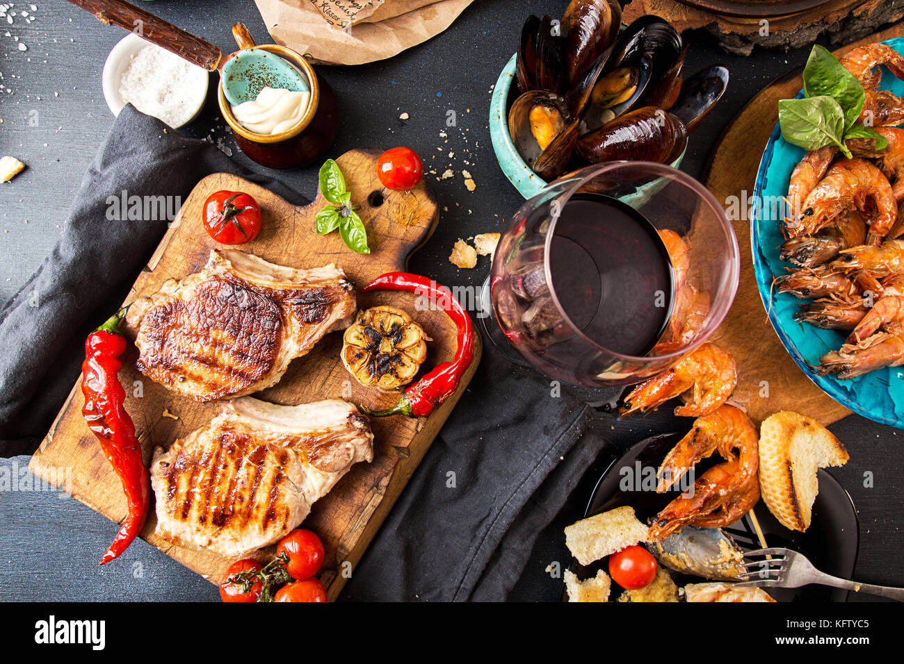 Overhead of dinner table. Assorted delicious grilled barbecue meat and ...