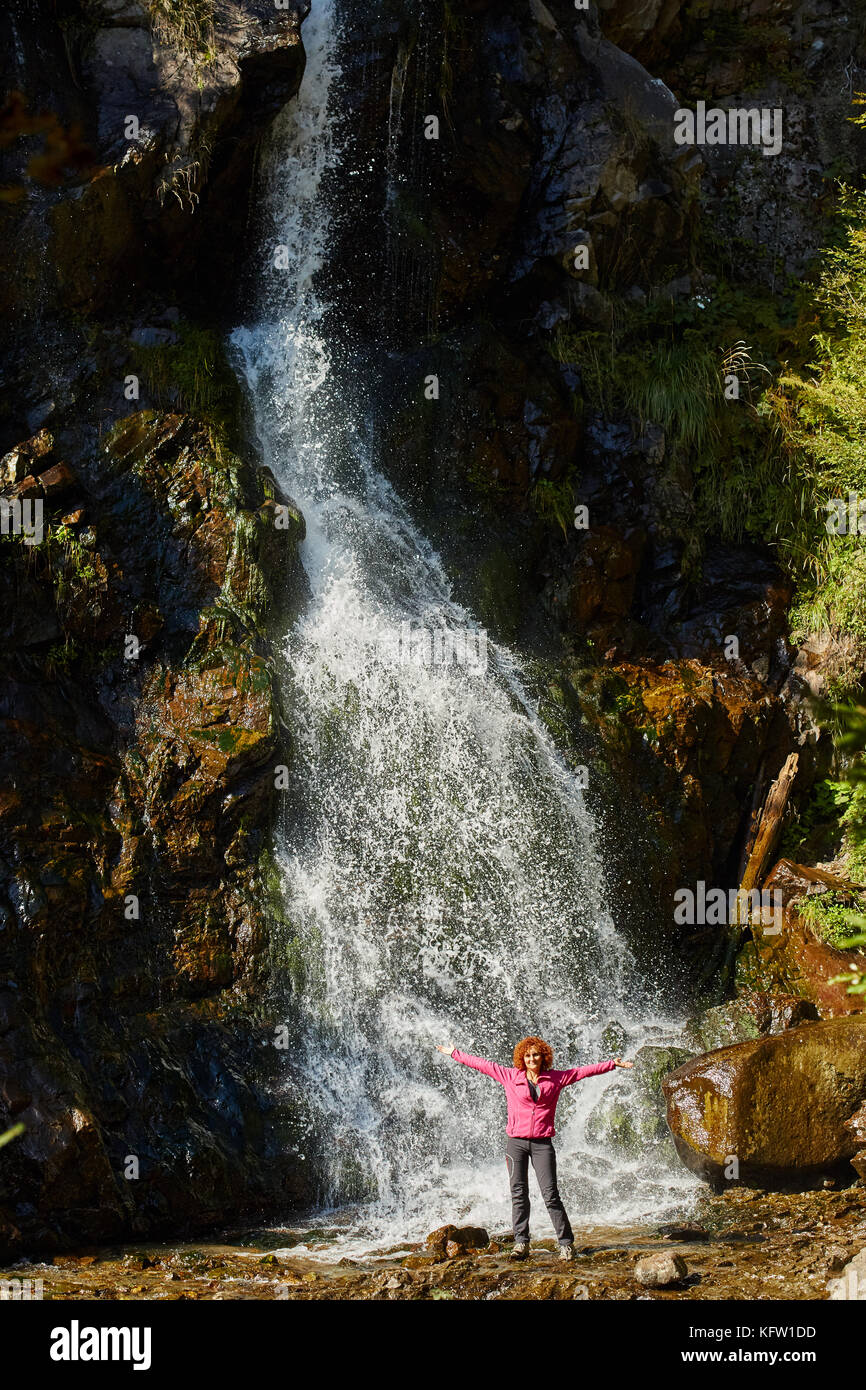 Woman posing in front of a waterfall Stock Photo - Alamy