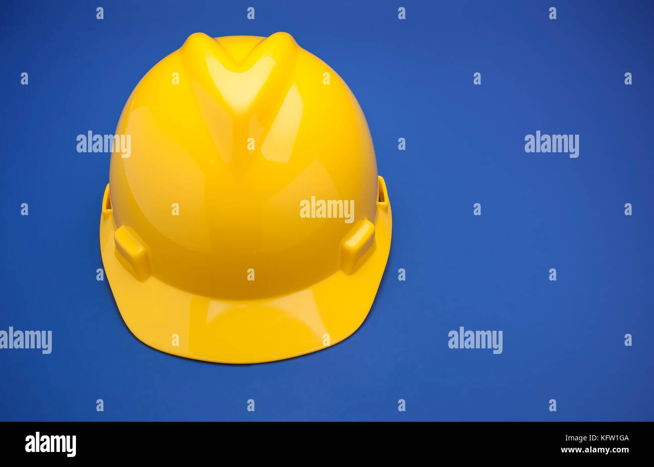 Yellow Hard Hat on Blue back drop Stock Photo - Alamy