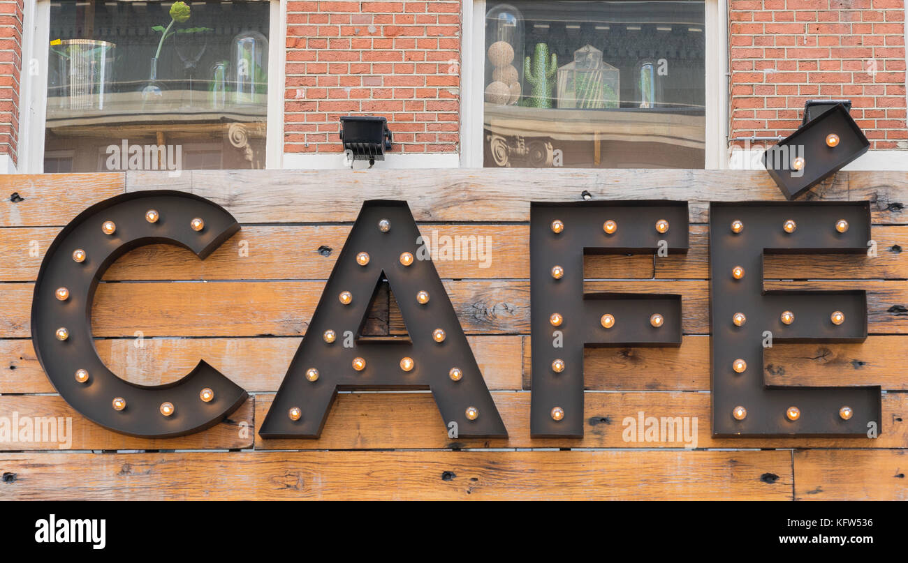 Trendy cafe sign on rustic backboard with windows above illuminated by ...