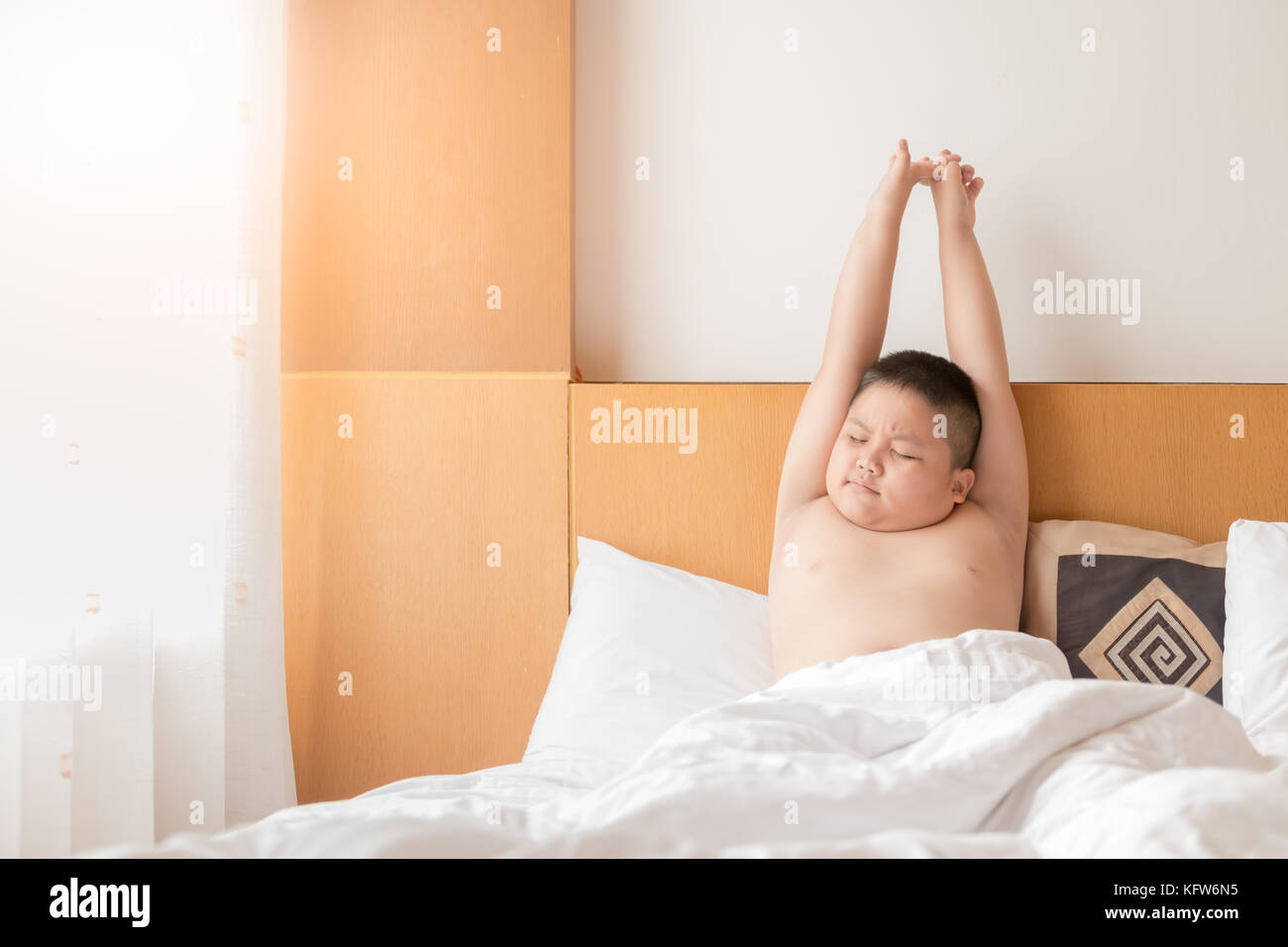 obese fat boy wakes up and stretching on bed in morning, Healthy ...